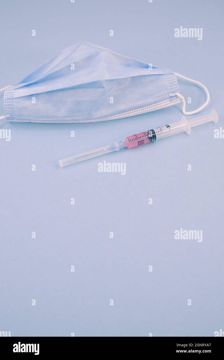 Isolated respiratory mask and syringe on a blue background Stock Photo ...