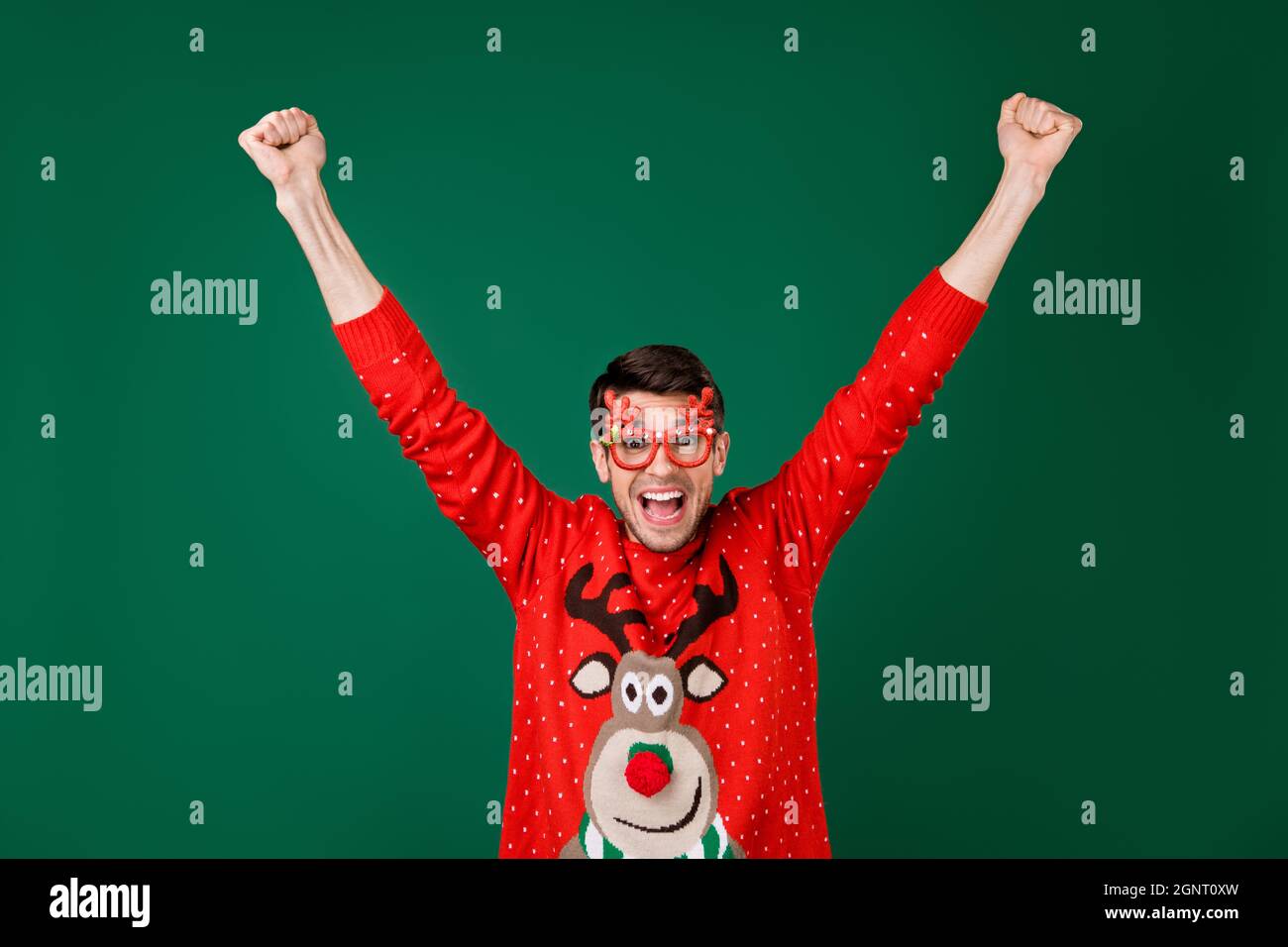 Portrait of attractive cheerful guy having fun rising hands up ...
