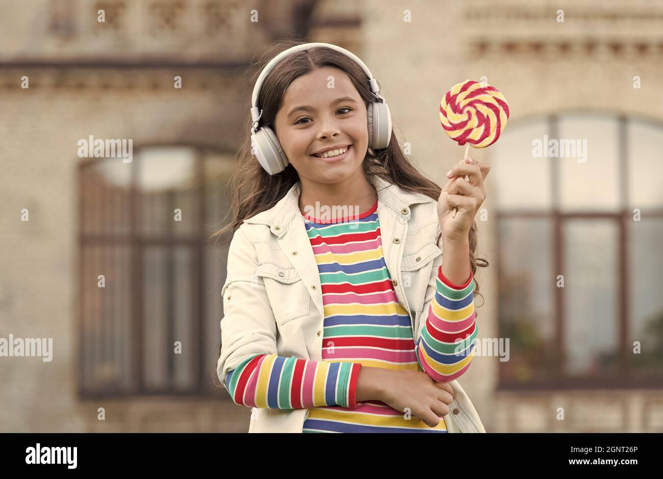 Girl wireless headphones eat lollipop candy, cute child concept Stock ...