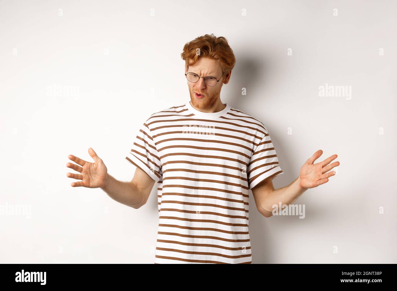 Impressed redhead man in glasses showing length of something big ...