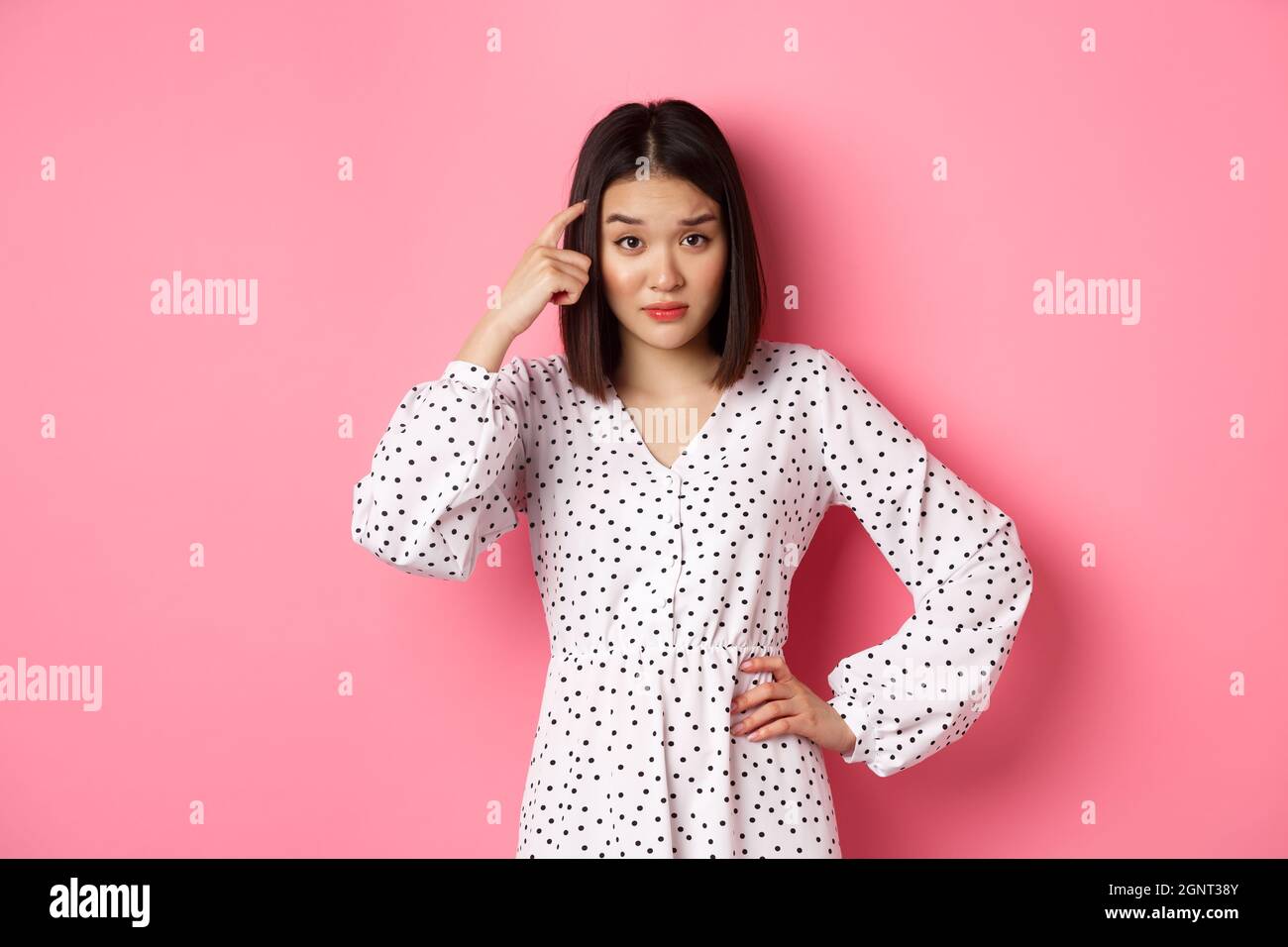 Image of attractive asian lady scolding person, pointing at head and ...