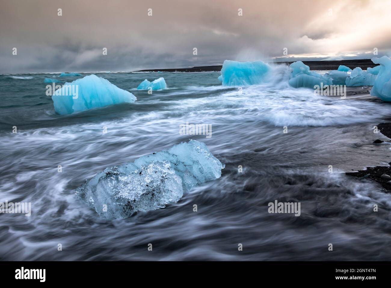 amazing blue colored icebergs washed ashore the black sand beach ...