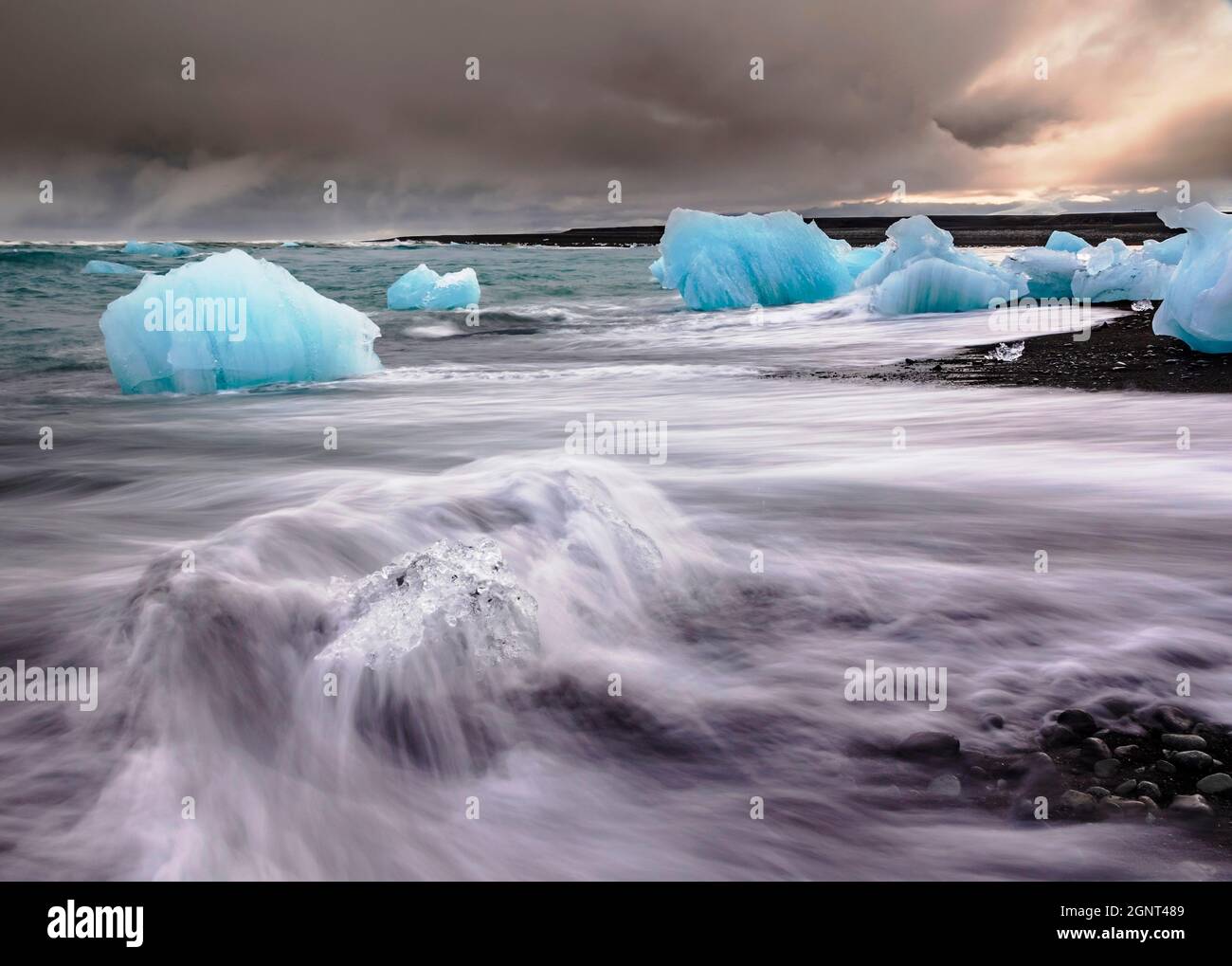 amazing blue colored icebergs washed ashore the black sand beach ...