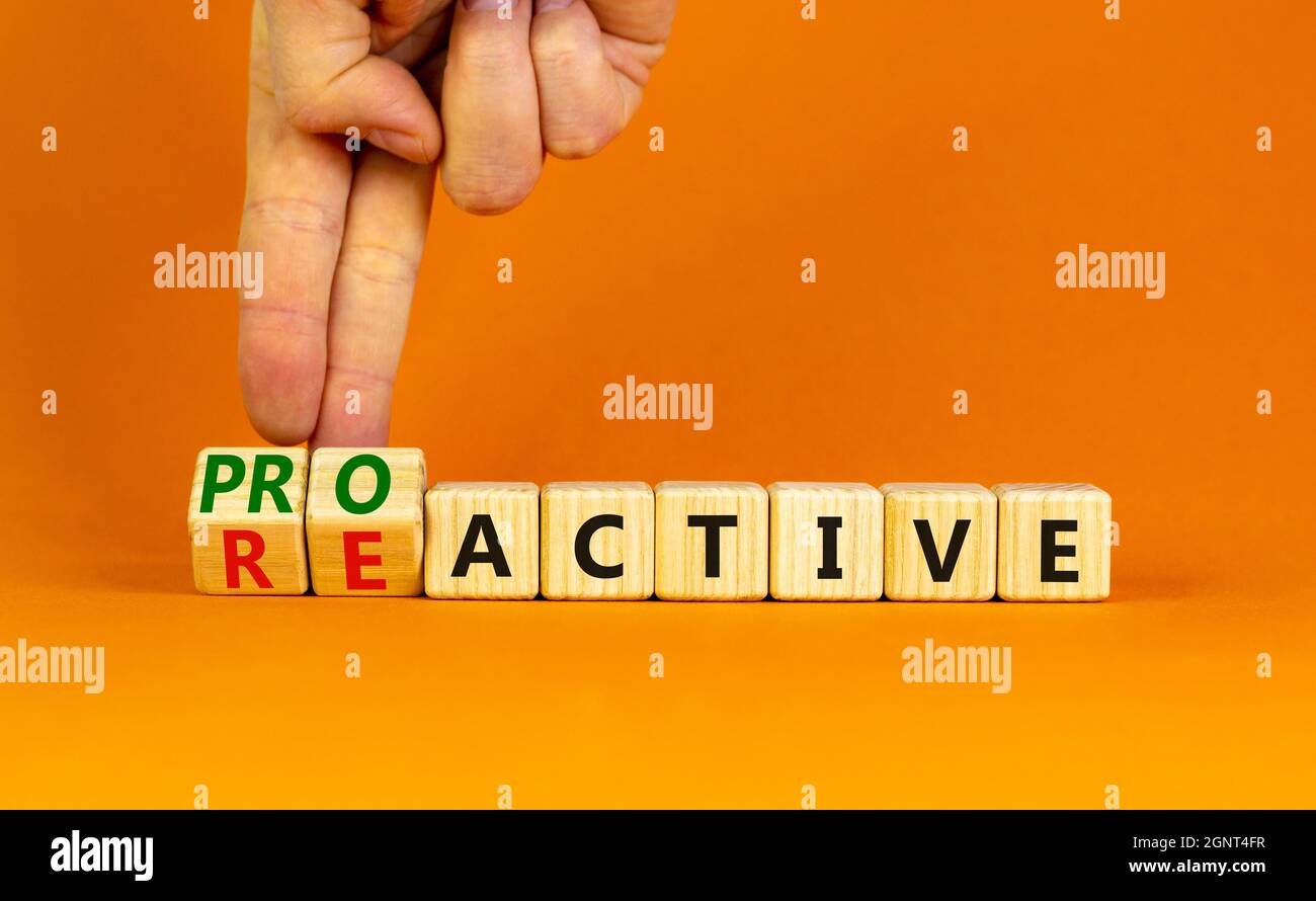 Reactive or proactive symbol. Businessman turns wooden cubes and ...