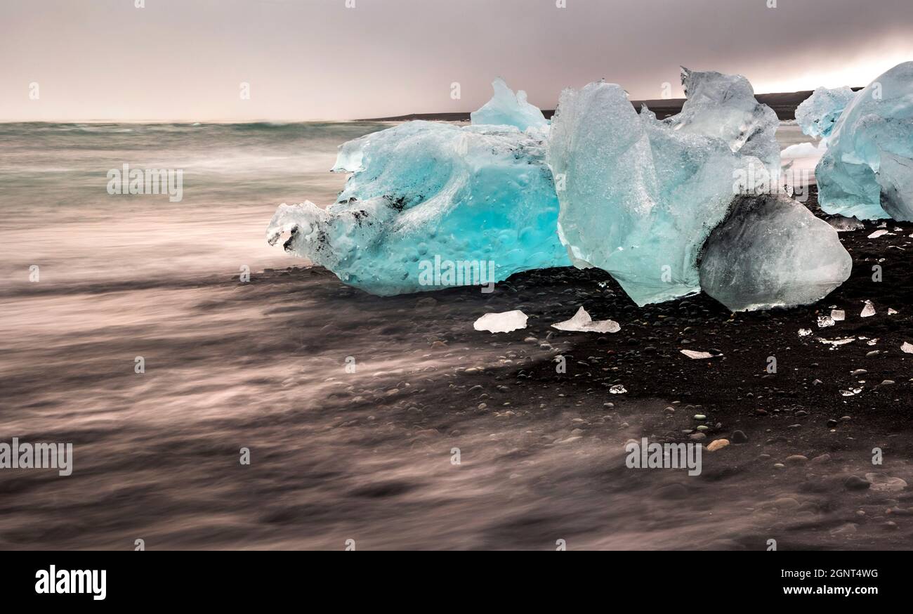 amazing blue colored icebergs washed ashore the black sand beach ...