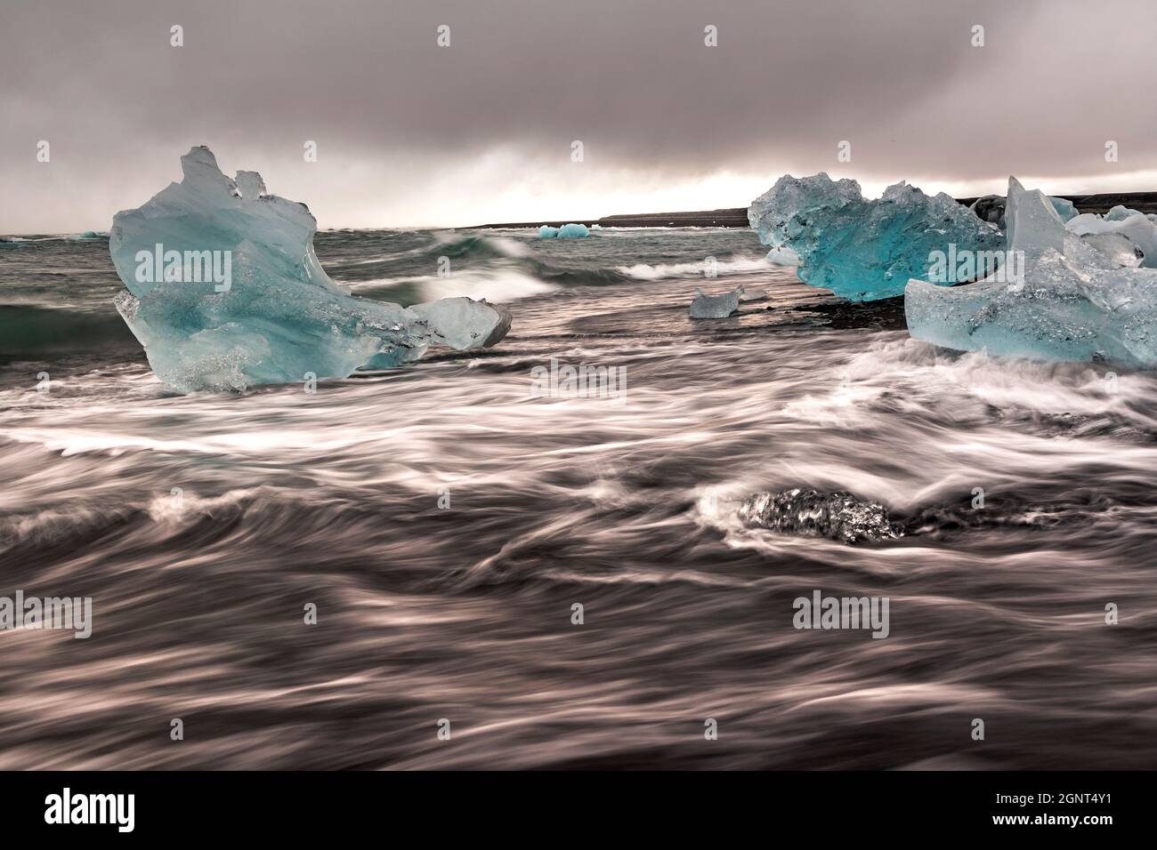 amazing blue colored icebergs washed ashore the black sand beach ...