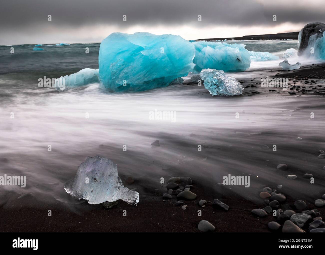 amazing blue colored icebergs washed ashore the black sand beach ...
