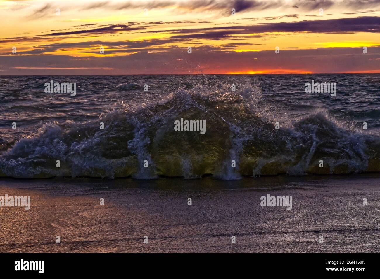 Lake Michigan wave splashing at end of pier at sunset Stock Photo - Alamy