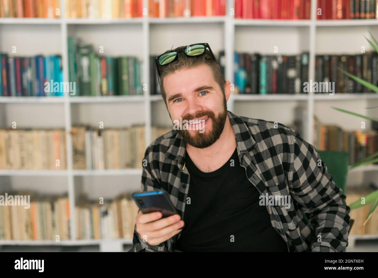 Attractive smiling hipster man relaxing at home. Gen Z and millennial ...