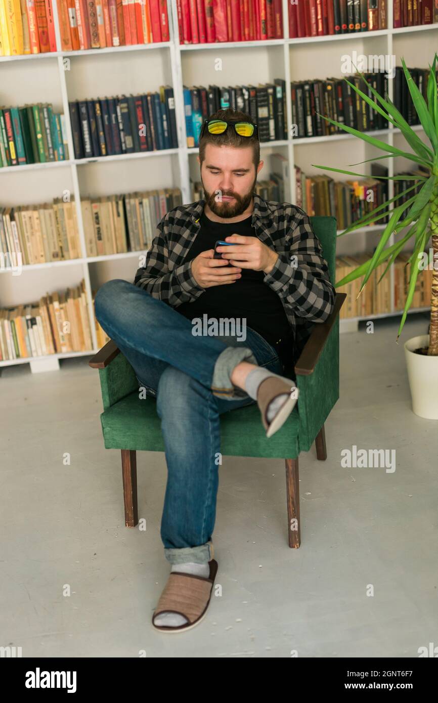 Attractive smiling hipster man relaxing at home. Gen Z and millennial ...