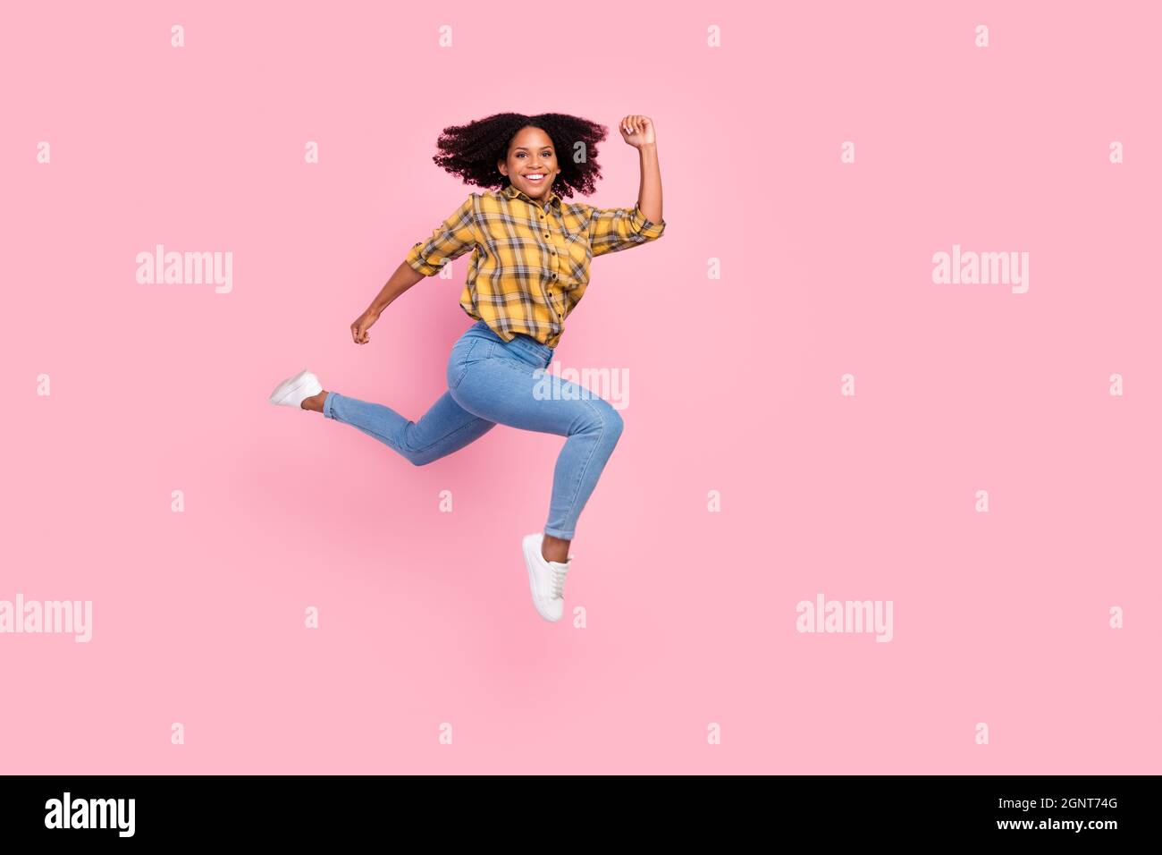 Photo of cheerful hurry lady jump run fast wear checkered shirt jeans ...