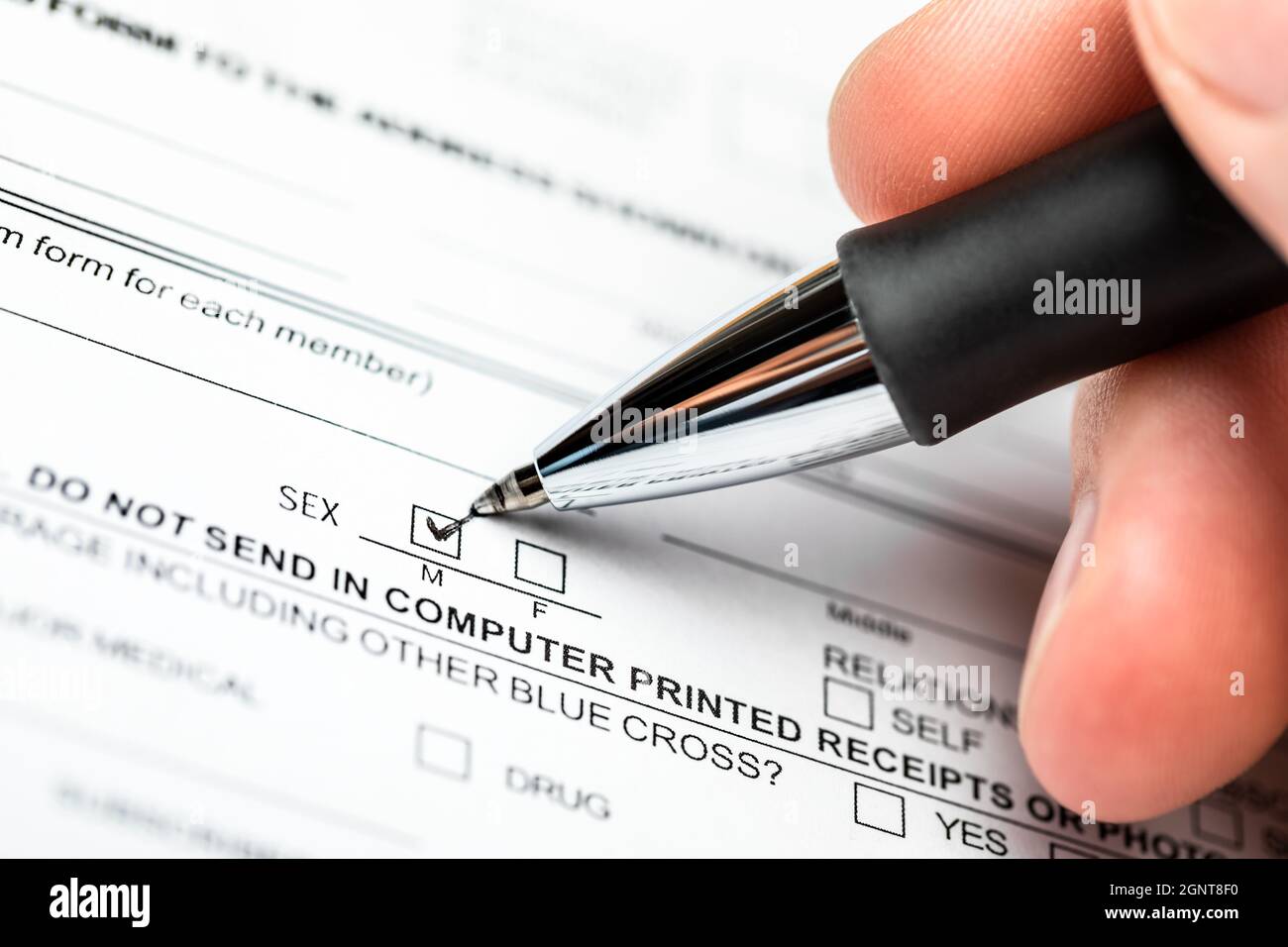 Person checking the male gender box on a document form with black ...