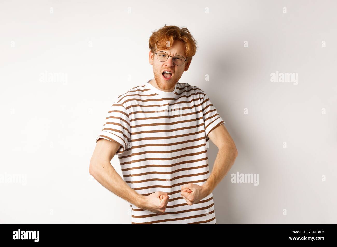 Image of confident and strong redhead man flexing biceps, showing ...