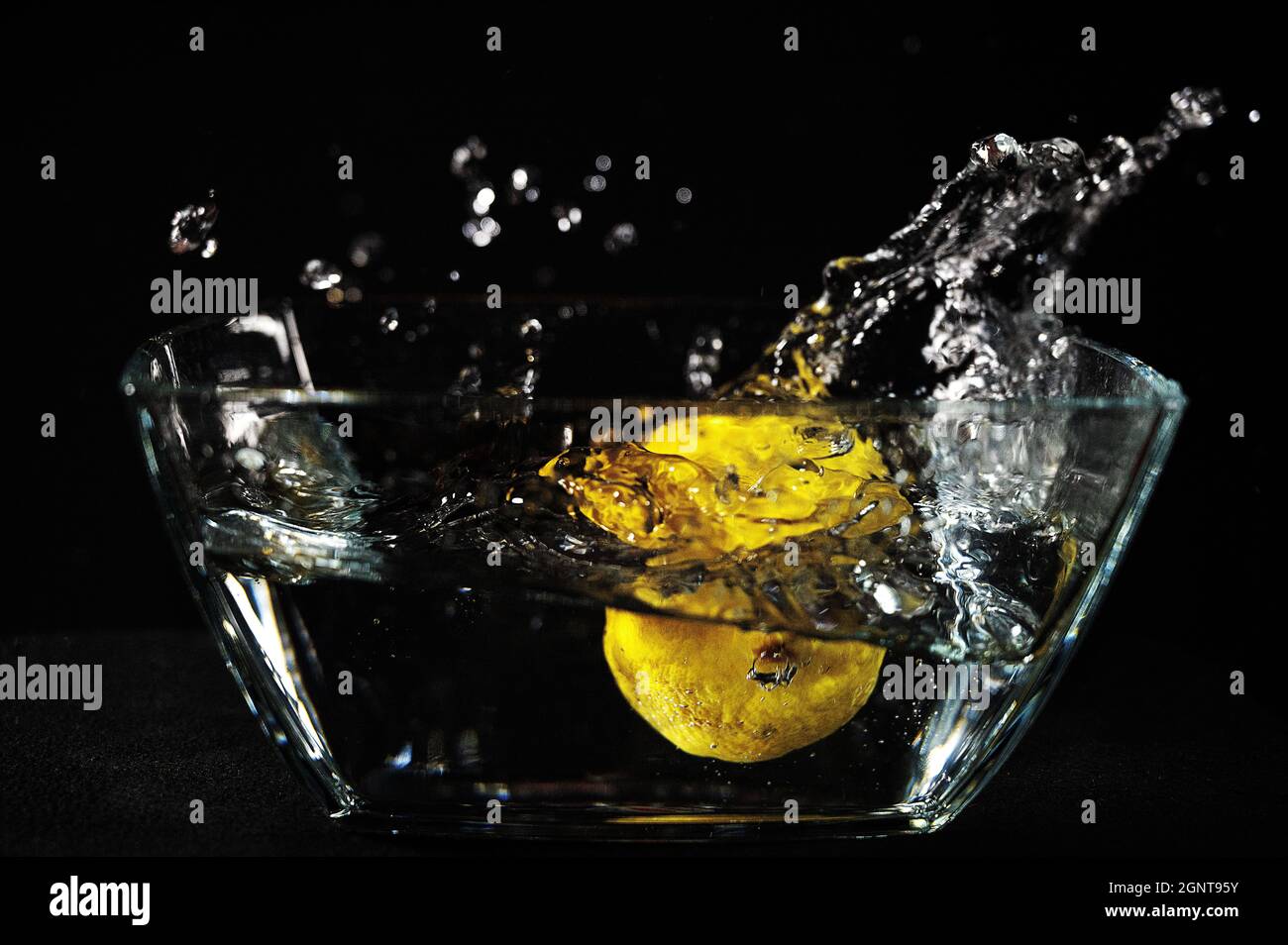 Yellow lemon in a water splash on a black background Stock Photo - Alamy
