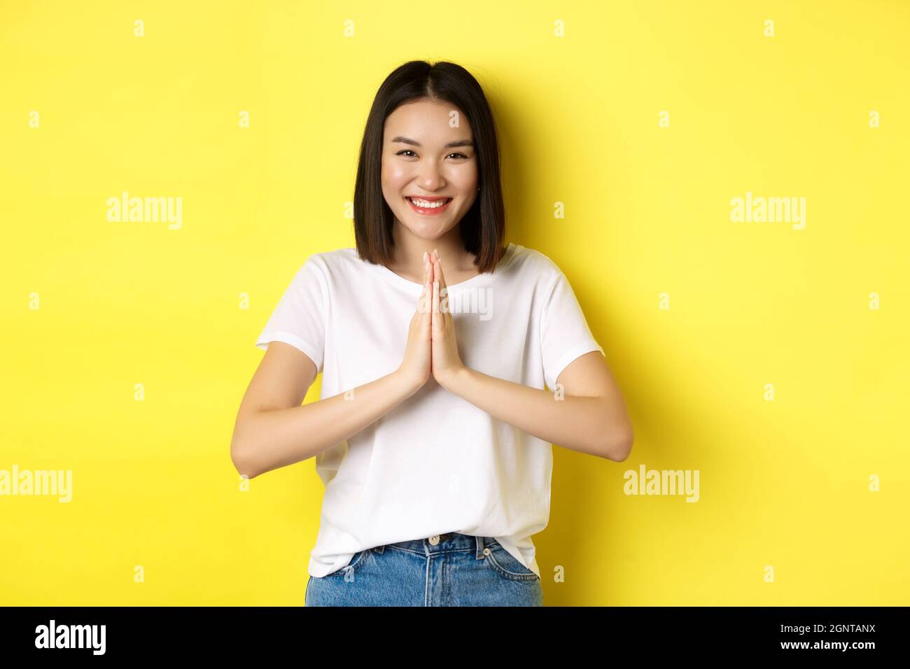 Beautiful asian woman say thank you, holding hands in namaste, pray ...
