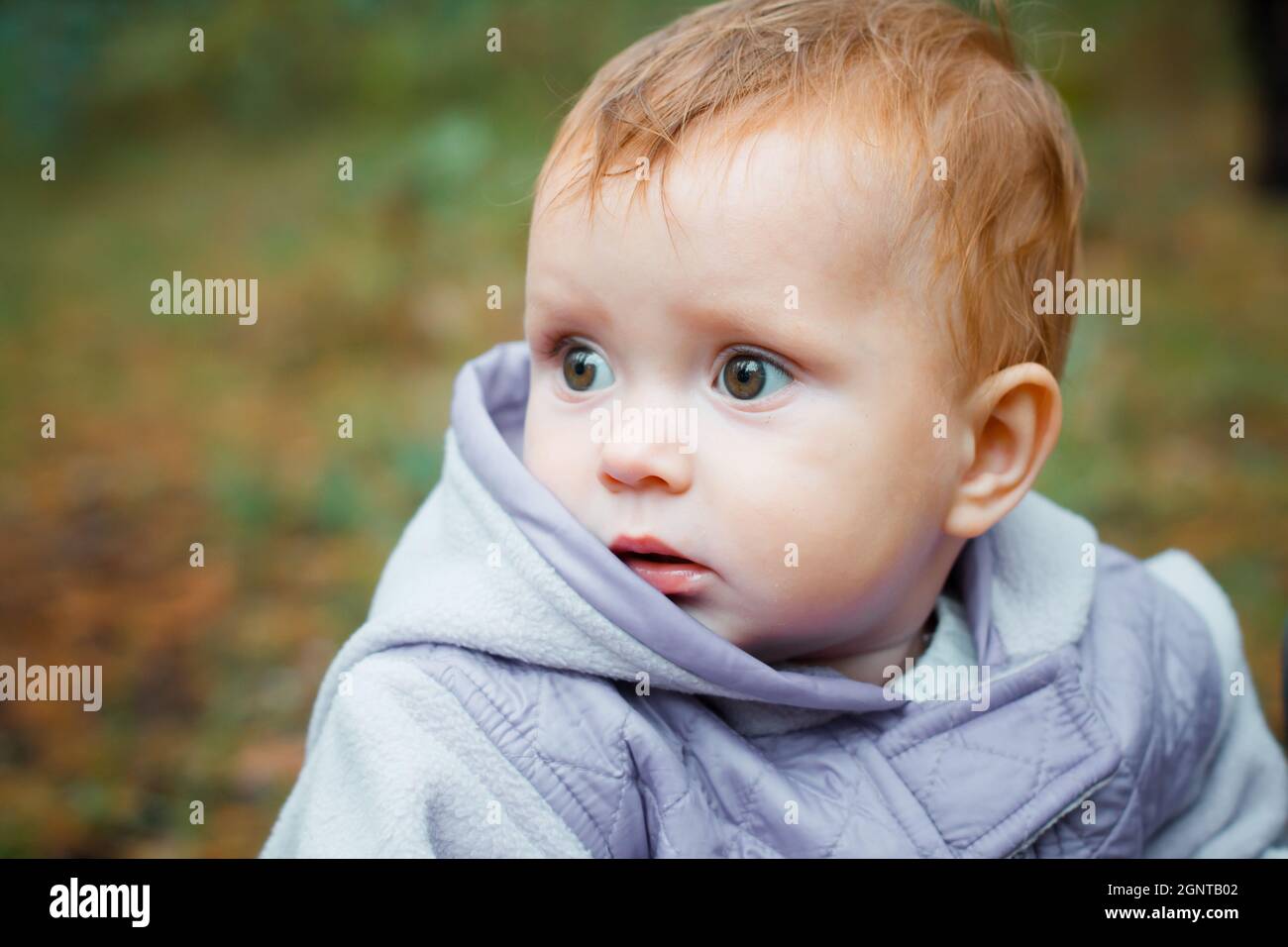Scared baby looks aside. A small child looks puzzled. A girl in a ...