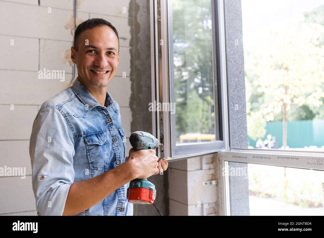 Construction worker installing window in house Stock Photo - Alamy