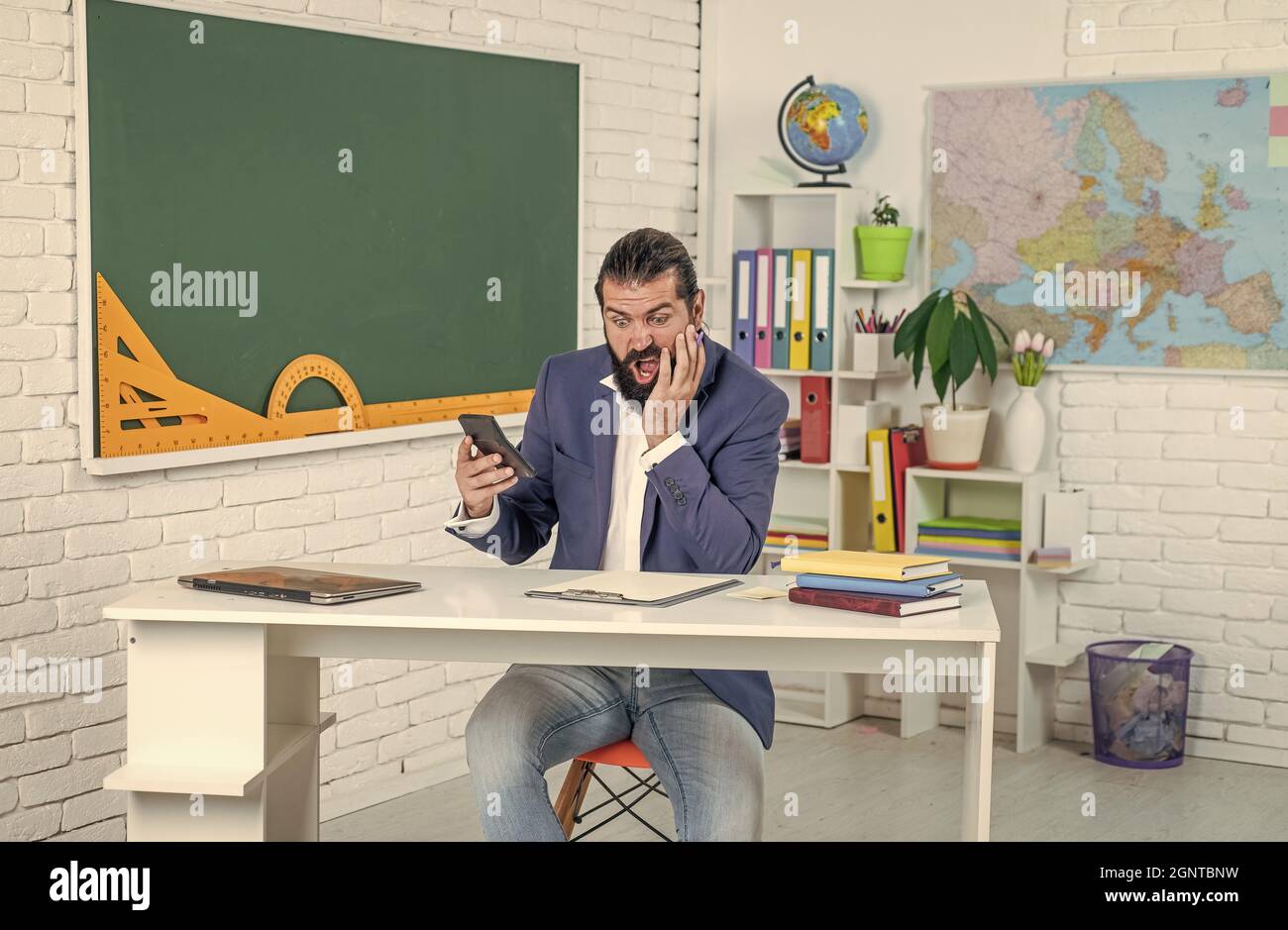 confused man with beard calculating on calculator in school math lesson ...