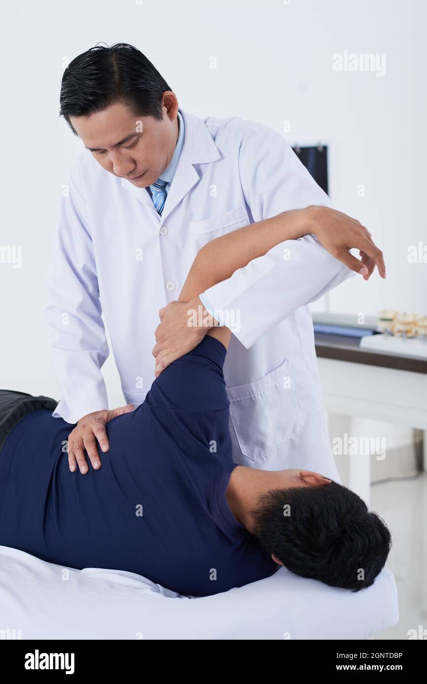 Vertical medium long shot of professional physical therapist working ...