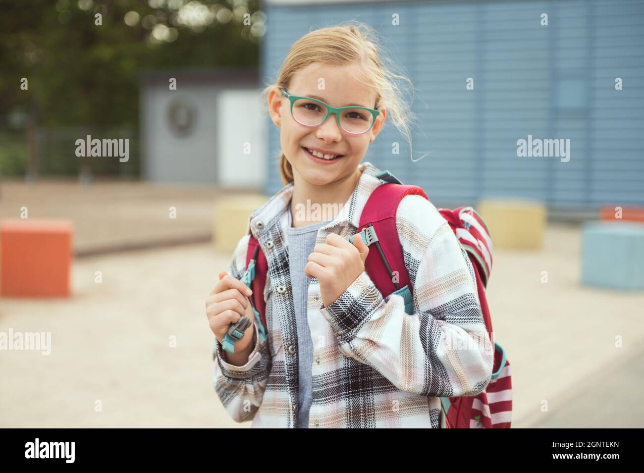 Portrait of pretty little school girl in glasses with backpack standing ...