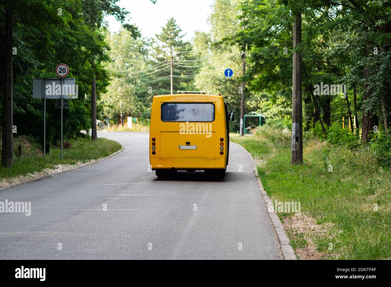 Departing bus. Back view of the bus. The bus was driving along a narrow ...