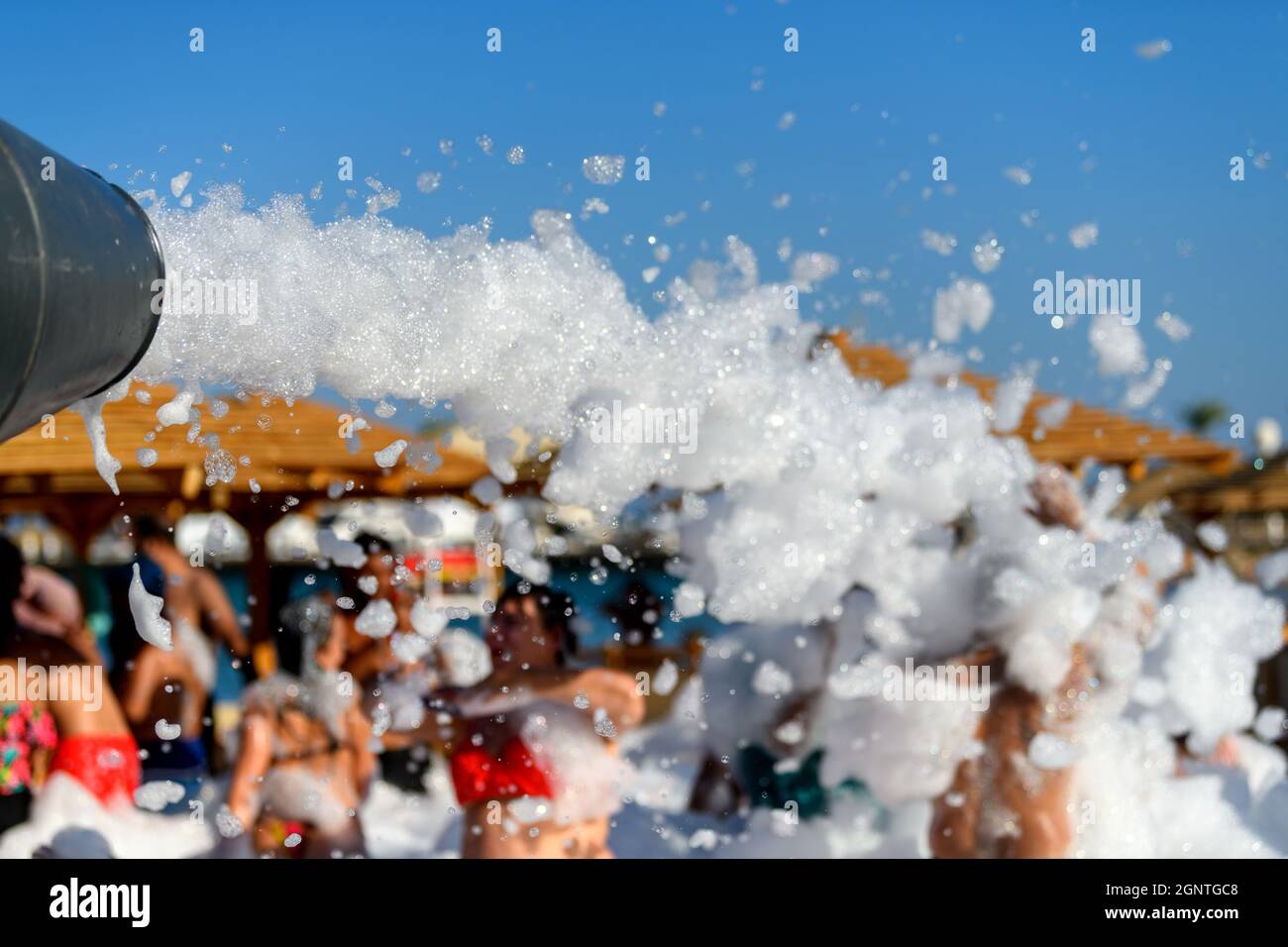 Fun foam party on the beach. Close texture foam on a blue sky ...