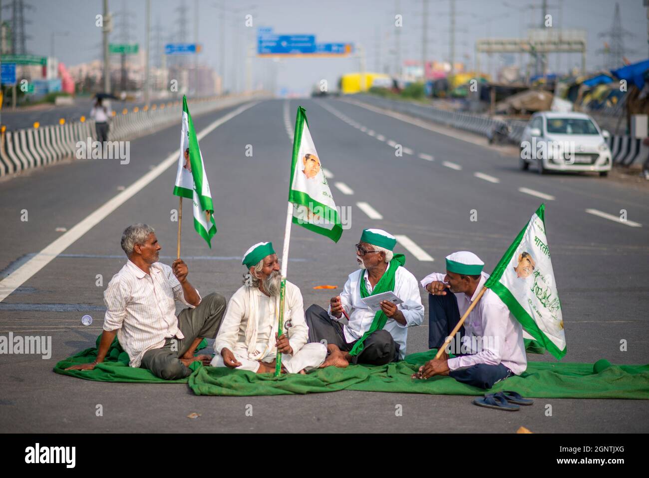 Ghaziabad, India. 27th Sep, 2021. Farmers sit on Road while holding ...