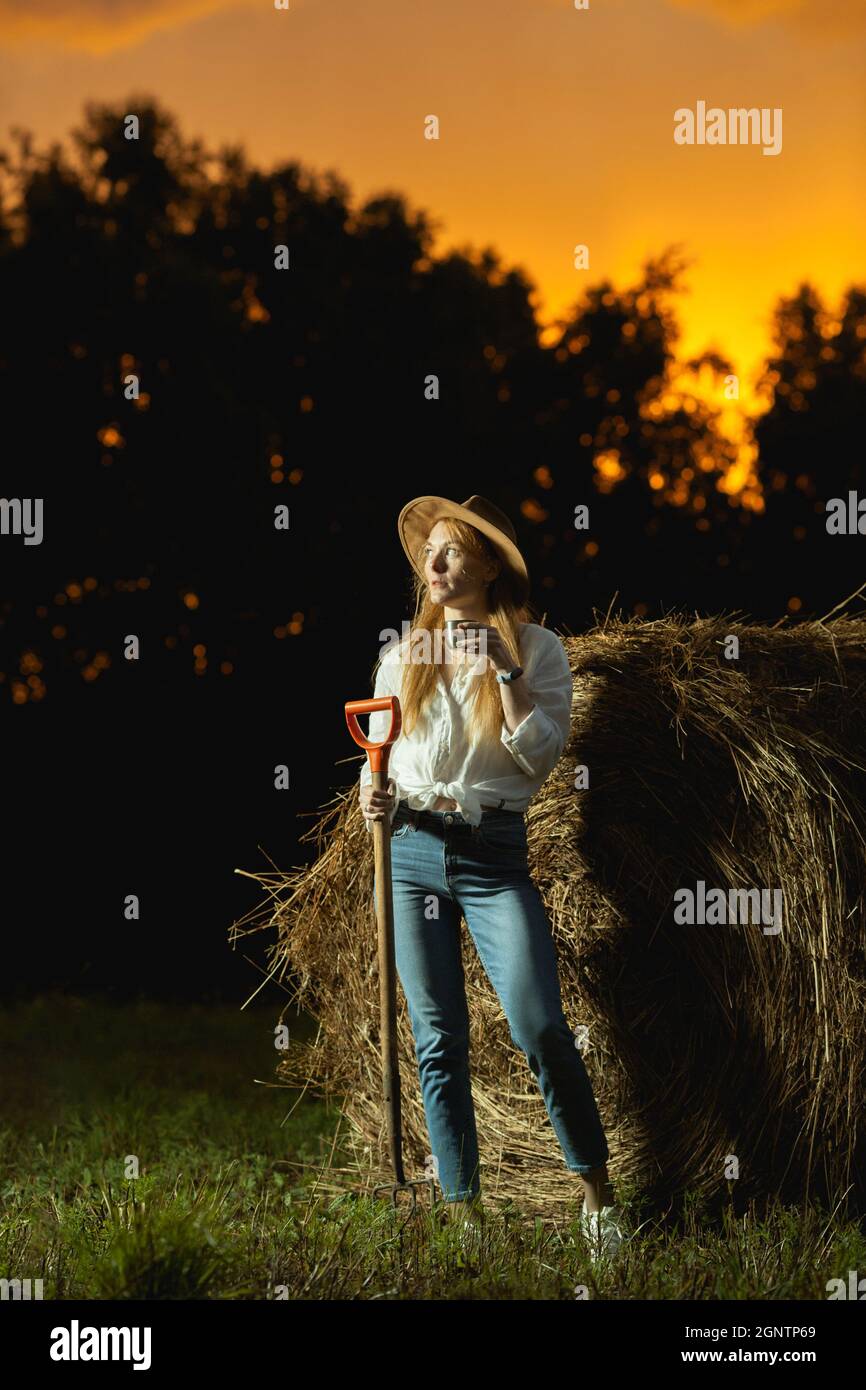 Country woman resting at the end of the working day. Girl in the wheat ...
