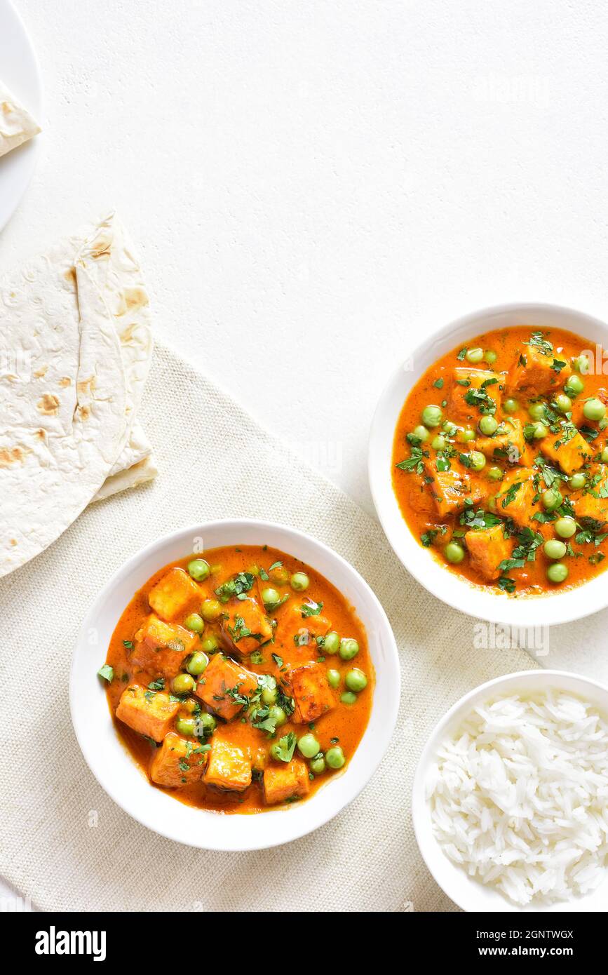 Indian style cottage cheese curry in bowls over white stone background ...