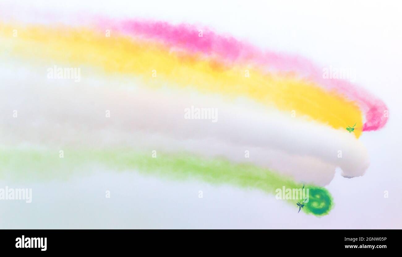 View of airplanes in the sky with pink, yellow, white, and green smoke ...