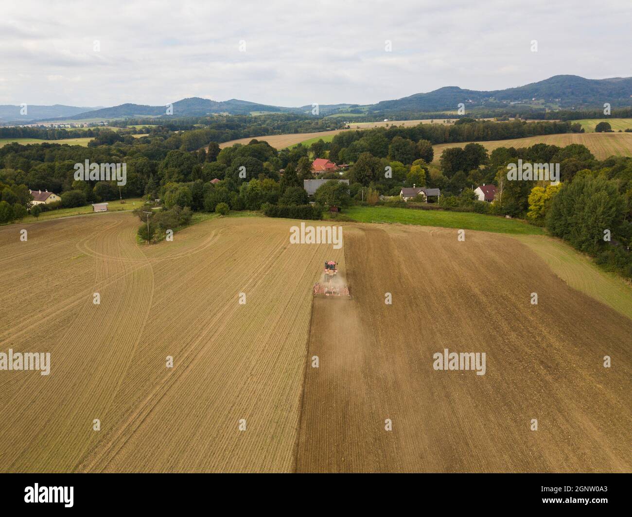 Aerial photo of a tractor ploughing stubble field in countryside ...