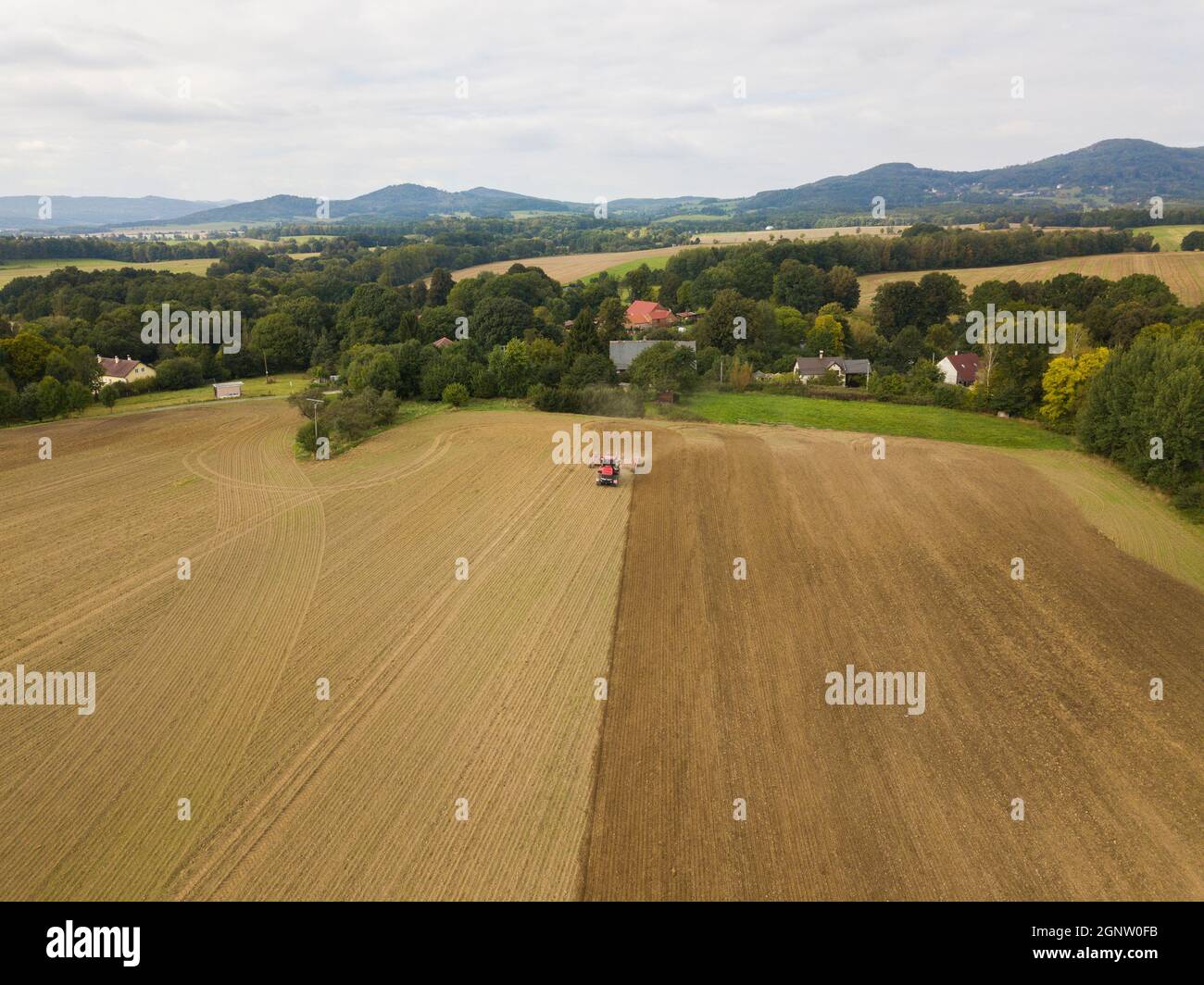 Aerial photo of a tractor ploughing stubble field in countryside ...