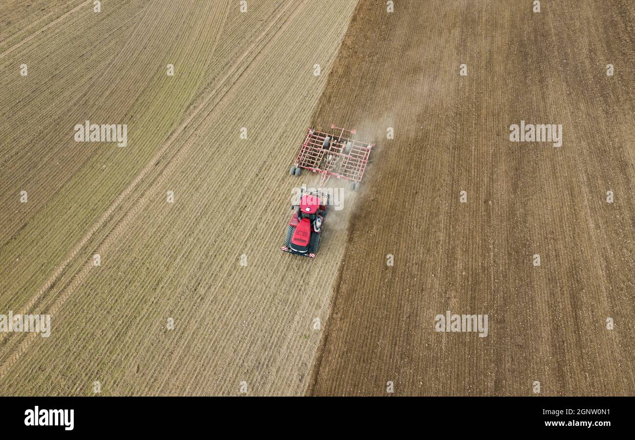 Aerial photo of a tractor ploughing stubble field in countryside ...