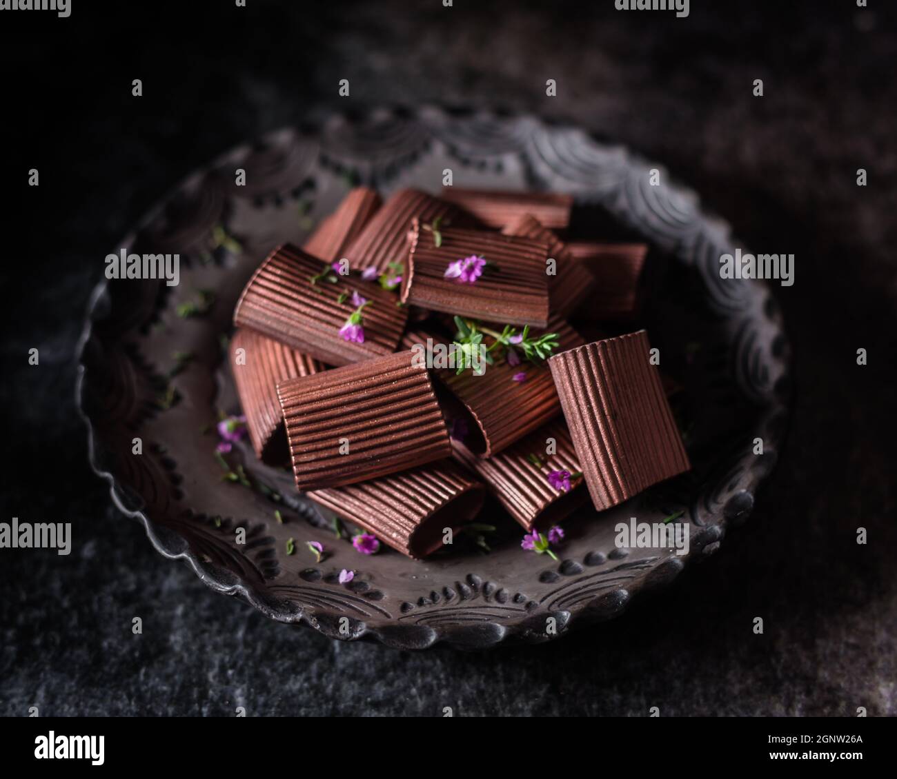Heap of chocolate candies on a black plate Stock Photo - Alamy