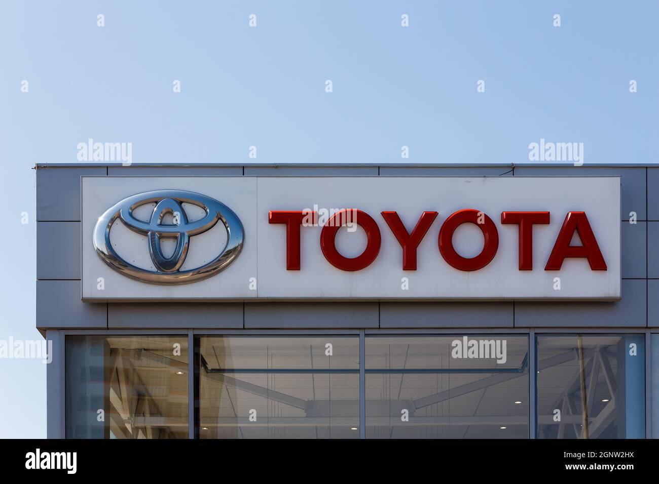 Toyota logo on car dealership building at sunny day - Toyota Motor ...