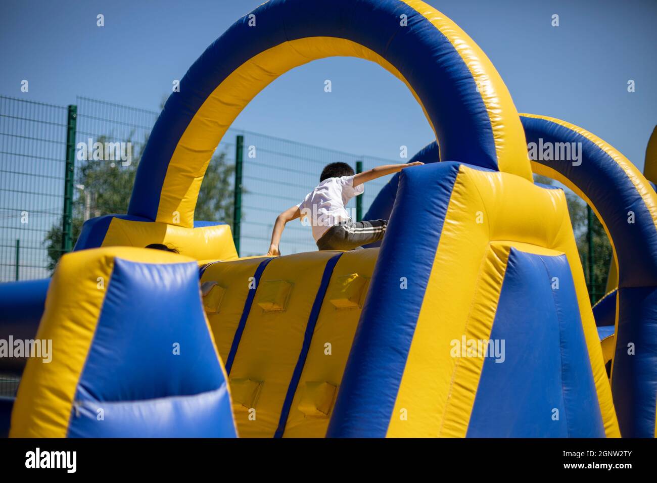 Children climb an inflatable slide. Inflatable obstacle course for fun ...