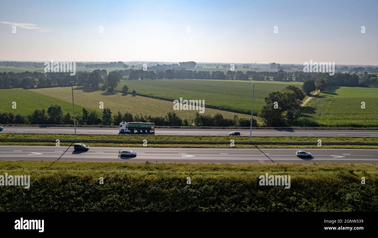 Aerial view of the road between farm fields and plantations under a ...