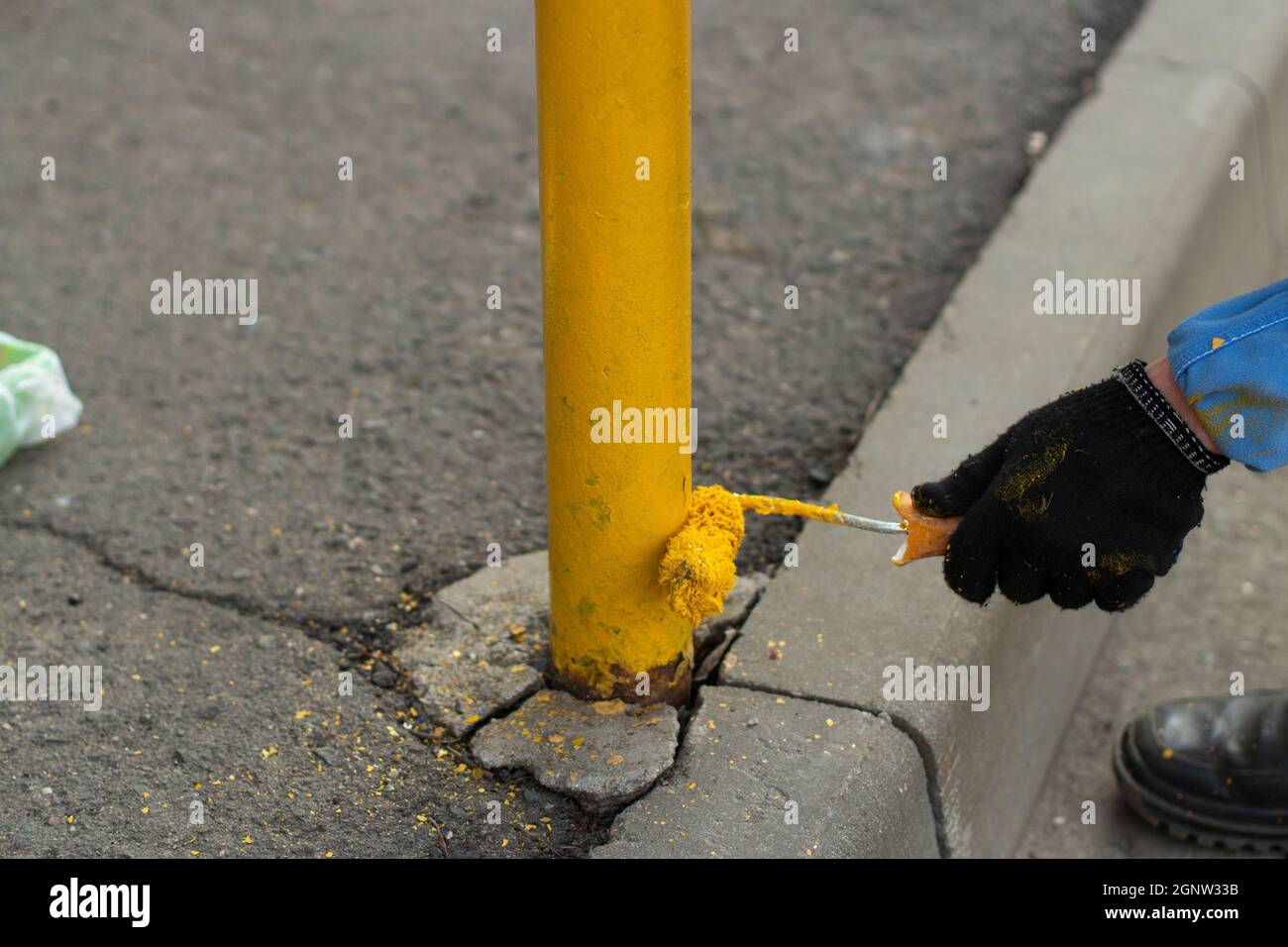 Painting a metal post with yellow paint. Parking bollard painting ...