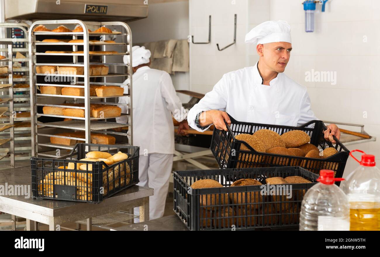 male baker with sesame bread in green box in kitchen Stock Photo - Alamy
