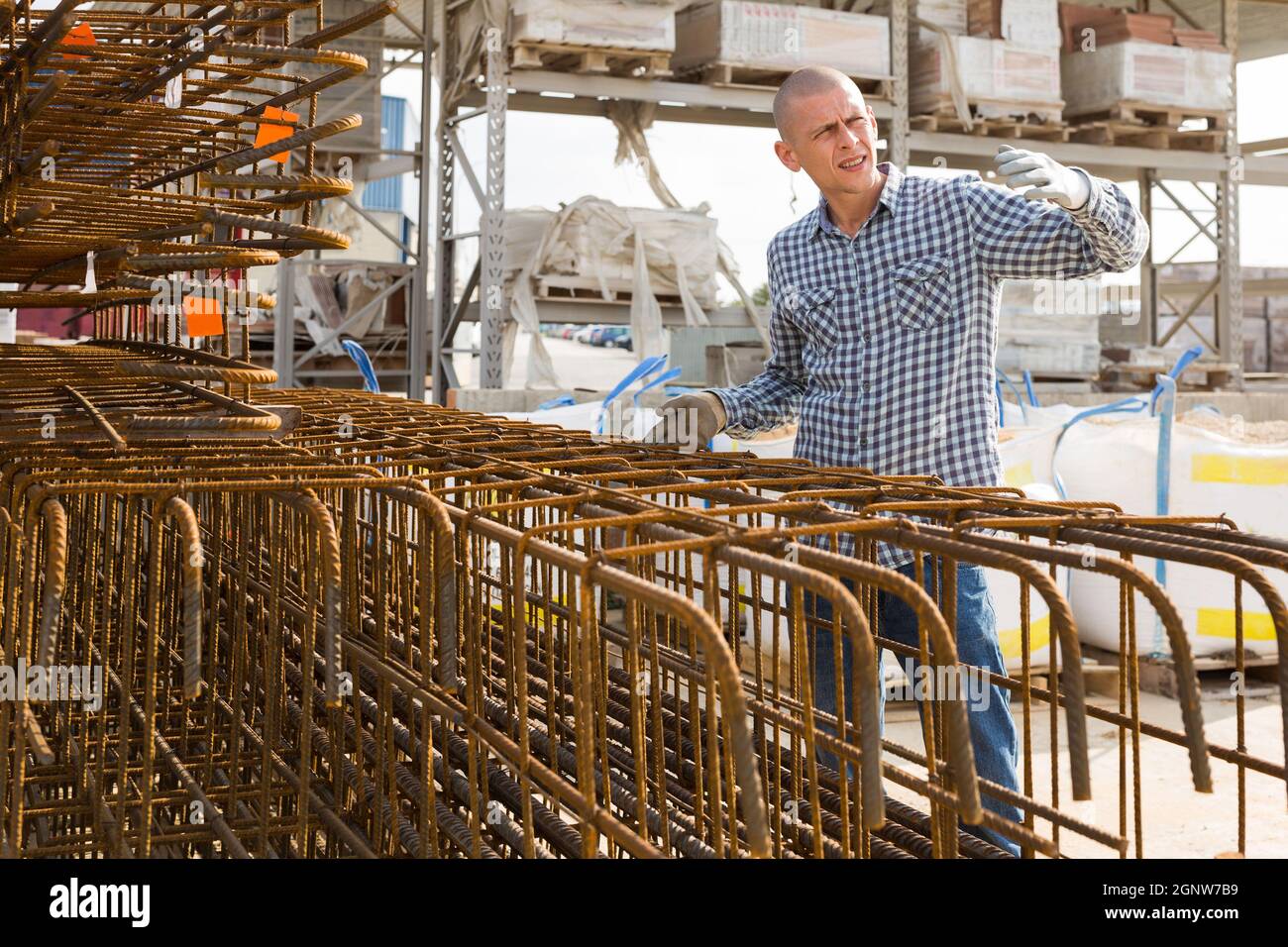 Construction shop worker prepares metal rebar for loading onto truck ...