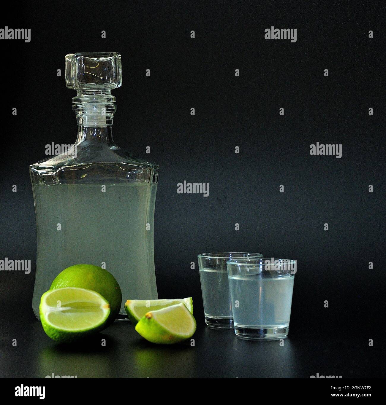 Lime-based liqueur, strong alcohol in a bottle and two glasses on a ...