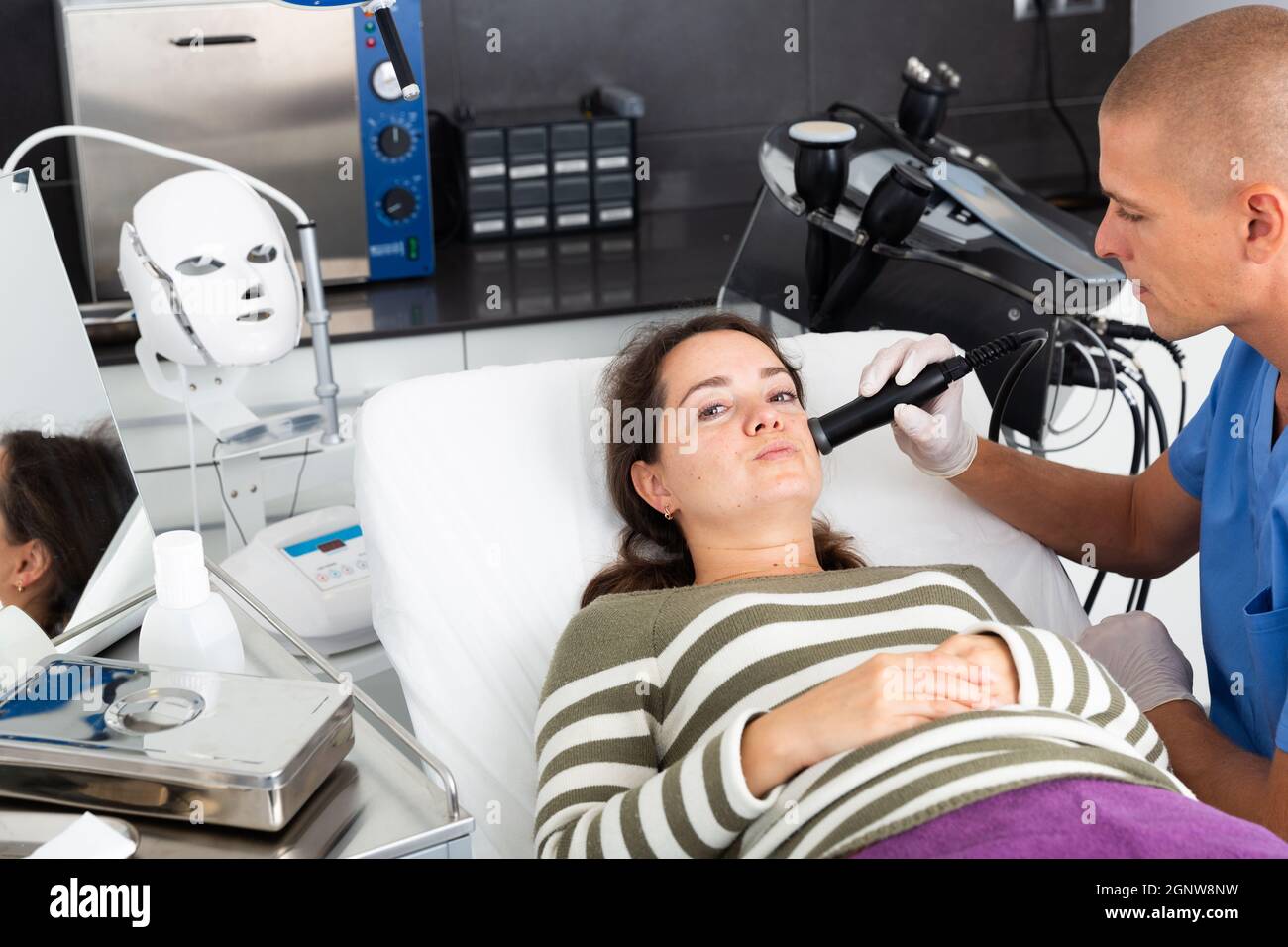 Woman getting facial electroporation procedure in aesthetic medicine ...