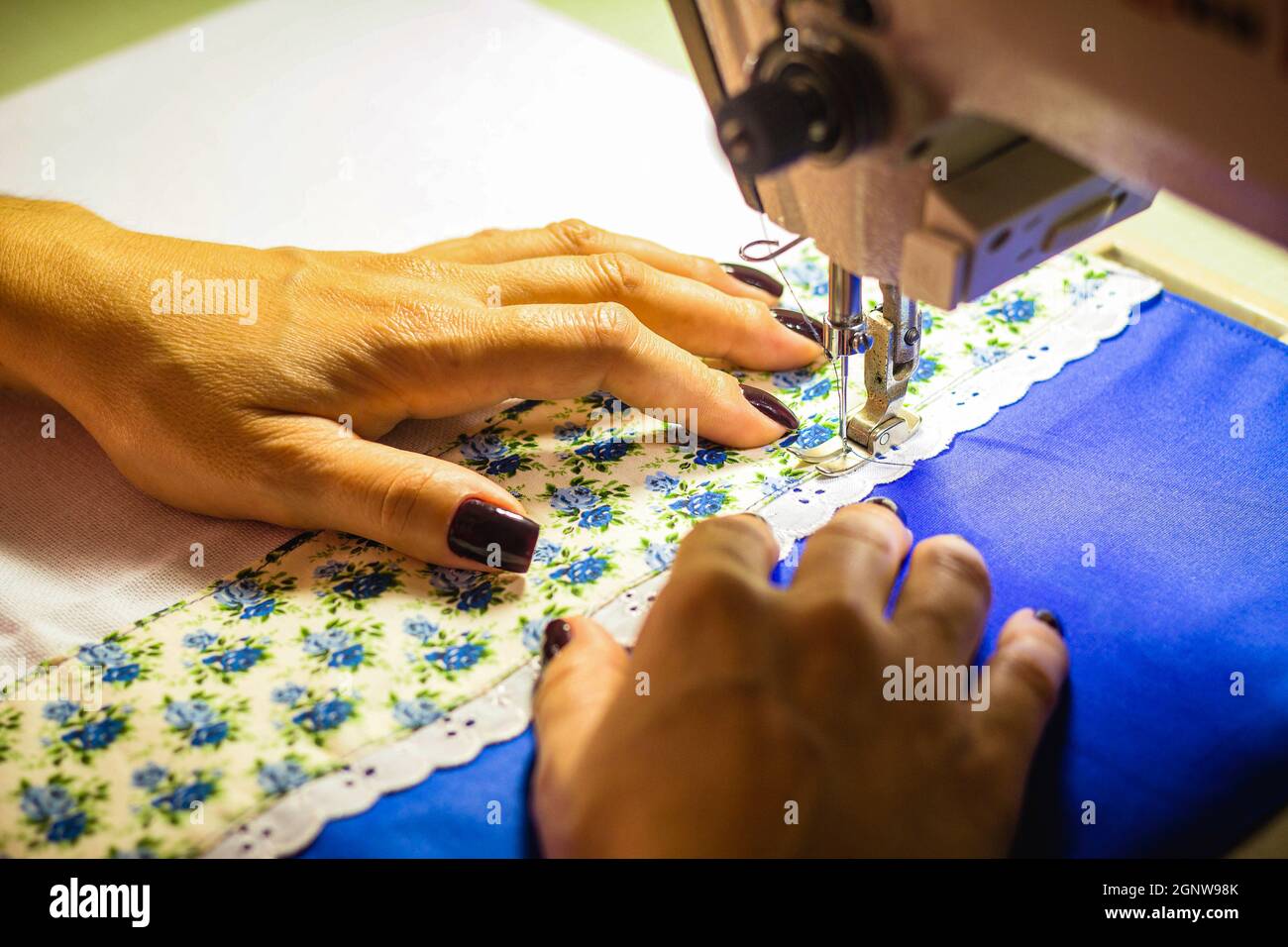 In this photo illustration a seamstress working on a sewing machine at ...