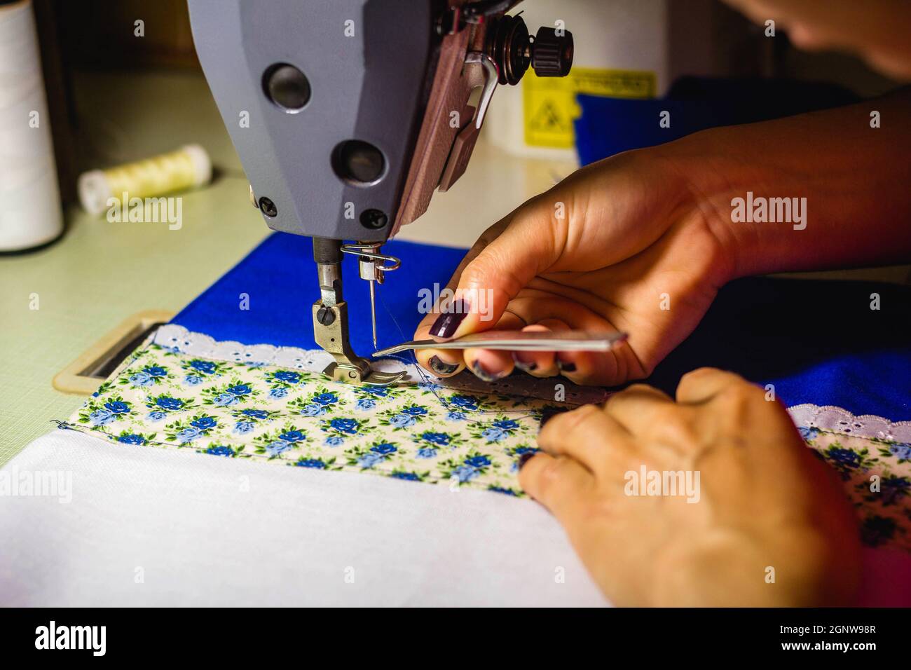 In this photo illustration a seamstress working on a sewing machine at ...