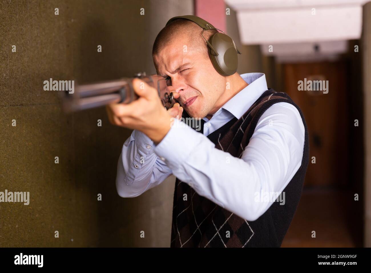 Man aims at a target with a double-barreled gun in shooting range Stock ...