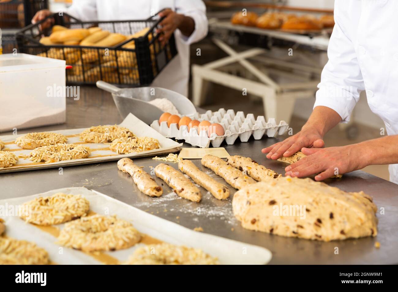Concentrated baker preparing sweet buns in bakery Stock Photo - Alamy