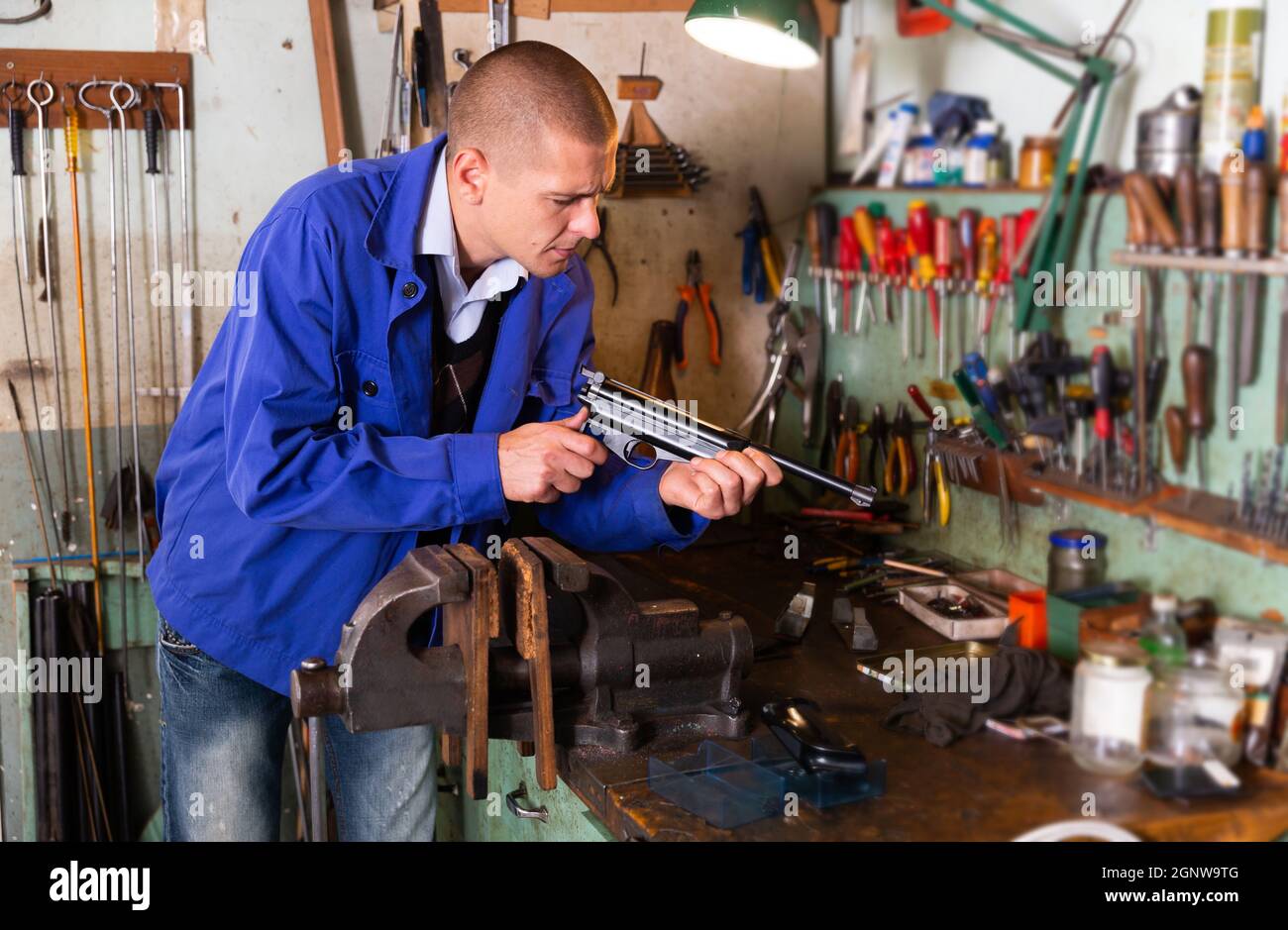 Gun repairman disassembling sporting handgun before preventive ...