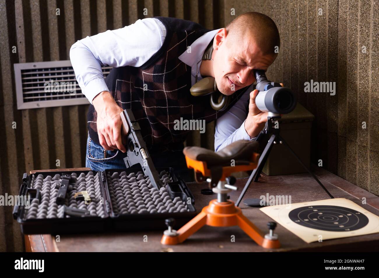 Man watching in monocle to check hitting target in shooting range Stock ...