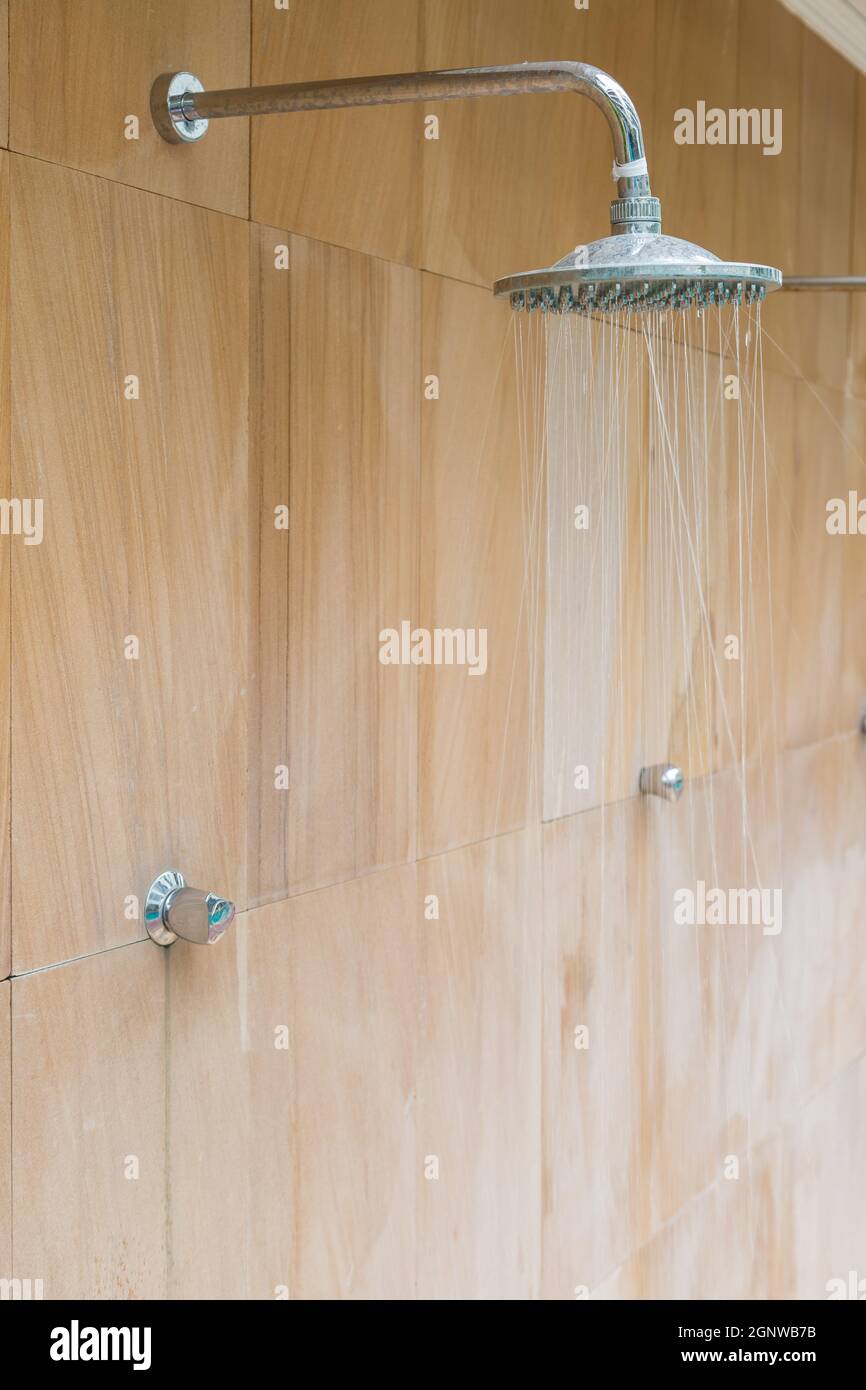 Outdoor shower sprinkler on brown wall background Stock Photo - Alamy