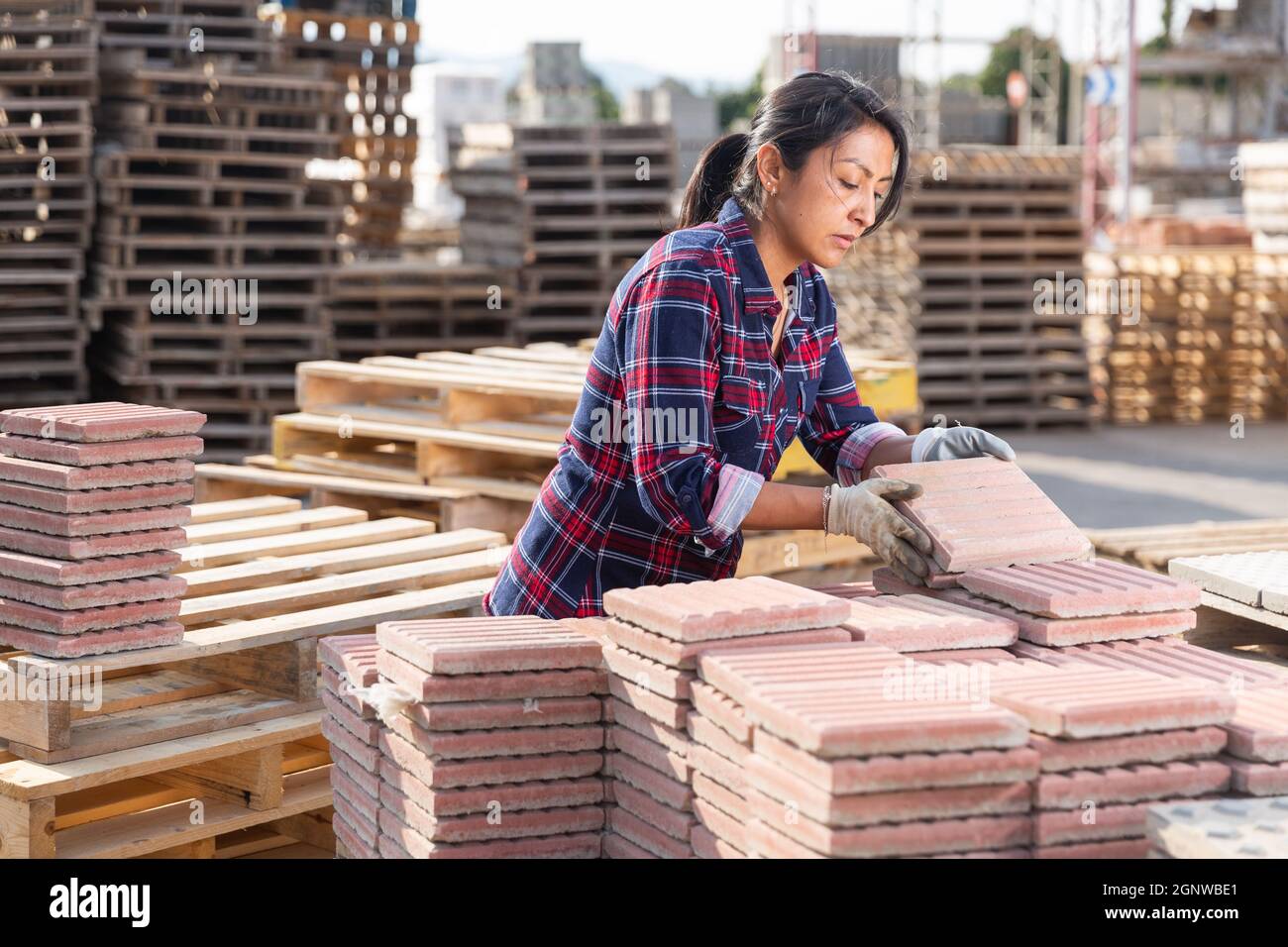 Latin american female stacking tiles on pallet Stock Photo - Alamy